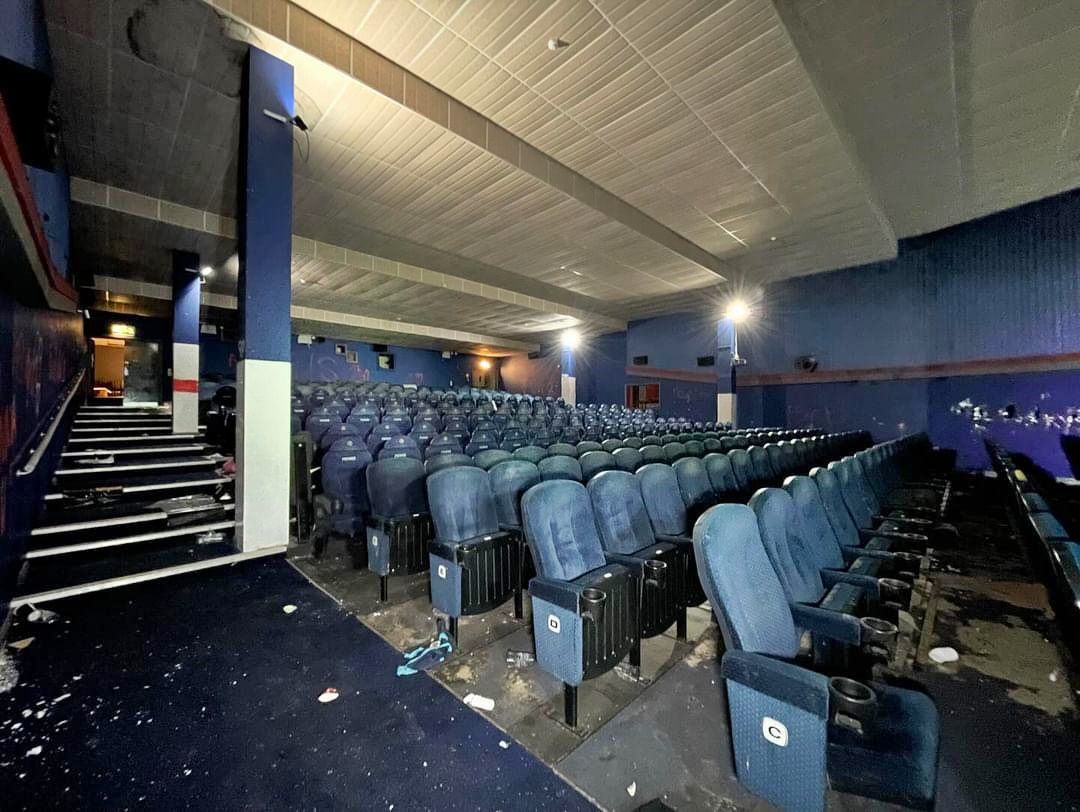 Eery abandoned cinema shown strewn with broken screens and empty ...